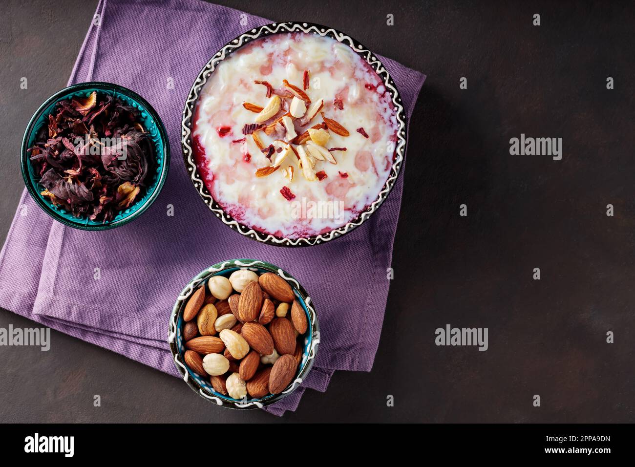 Rice kheer with sprinkled nuts on dark background. Rice pudding served ...