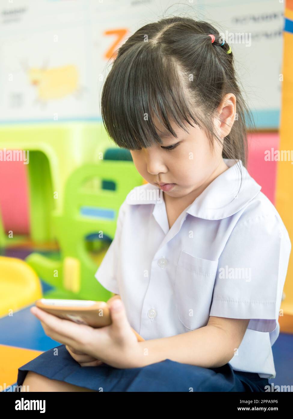 Asian child girl look smart phone Stock Photo - Alamy