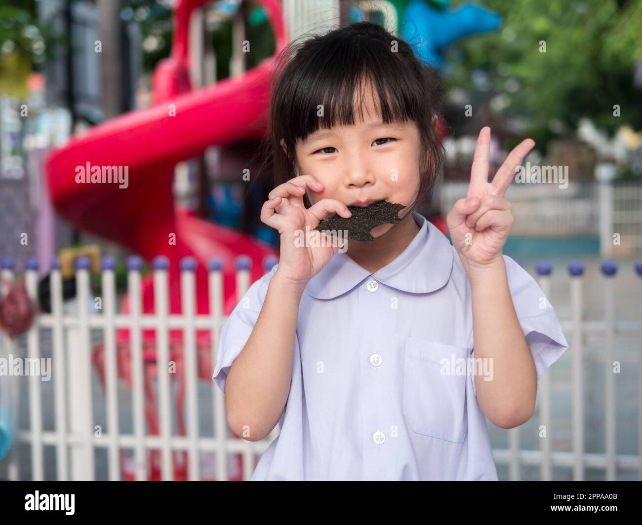 Happy Asian child eating delicious nori seaweed Stock Photo - Alamy