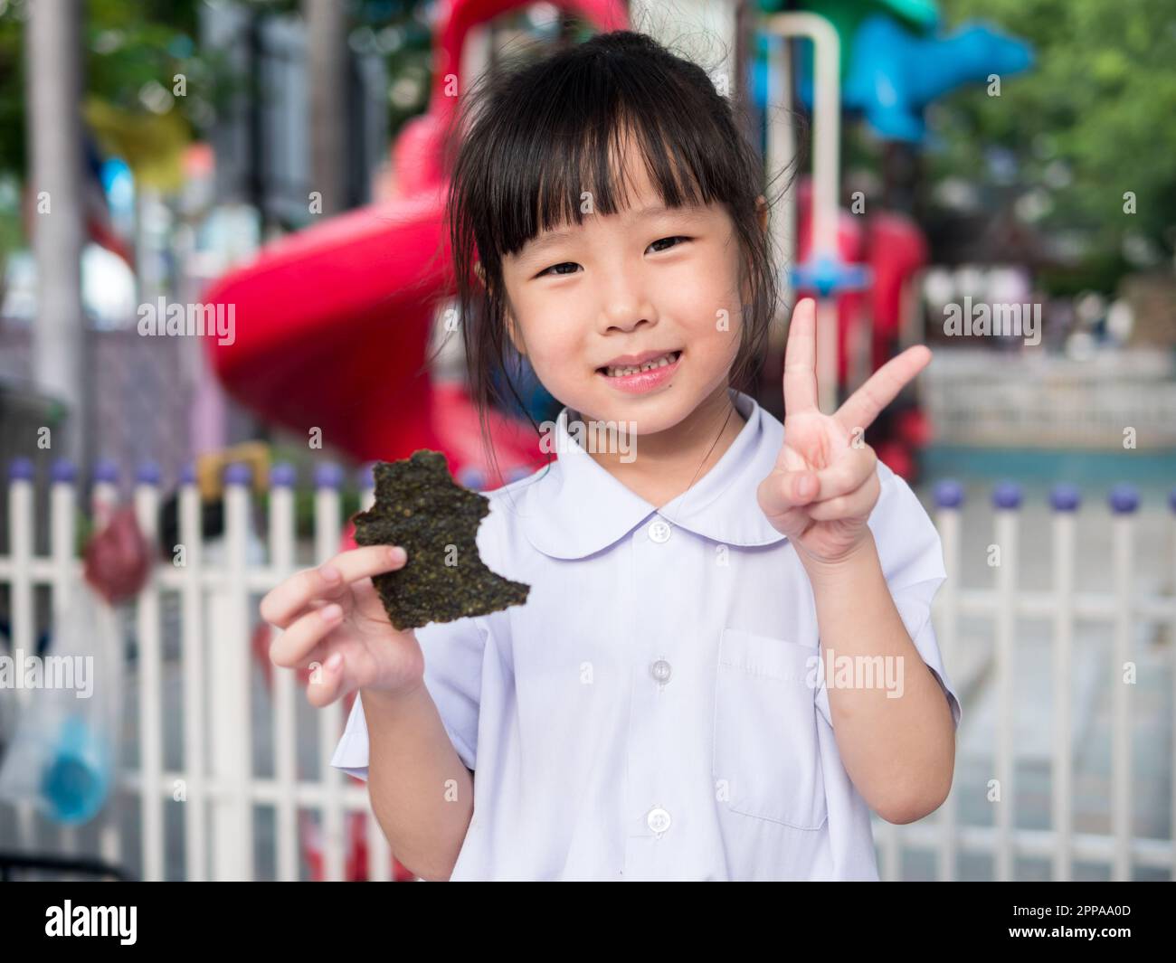 Happy Asian child eating delicious nori seaweed Stock Photo - Alamy