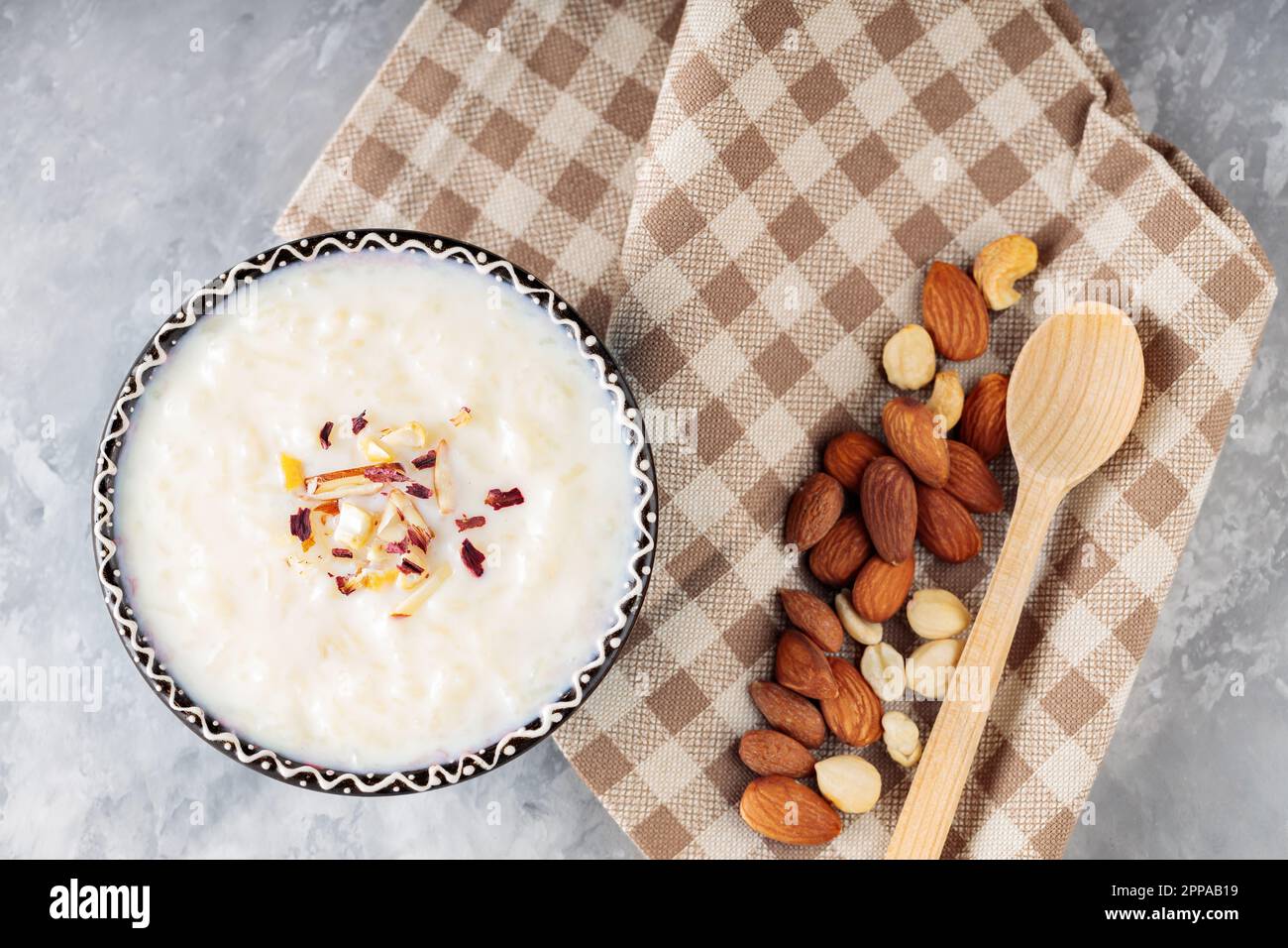 Indian rice kheer with nuts on a gray background. Bowl with rice ...