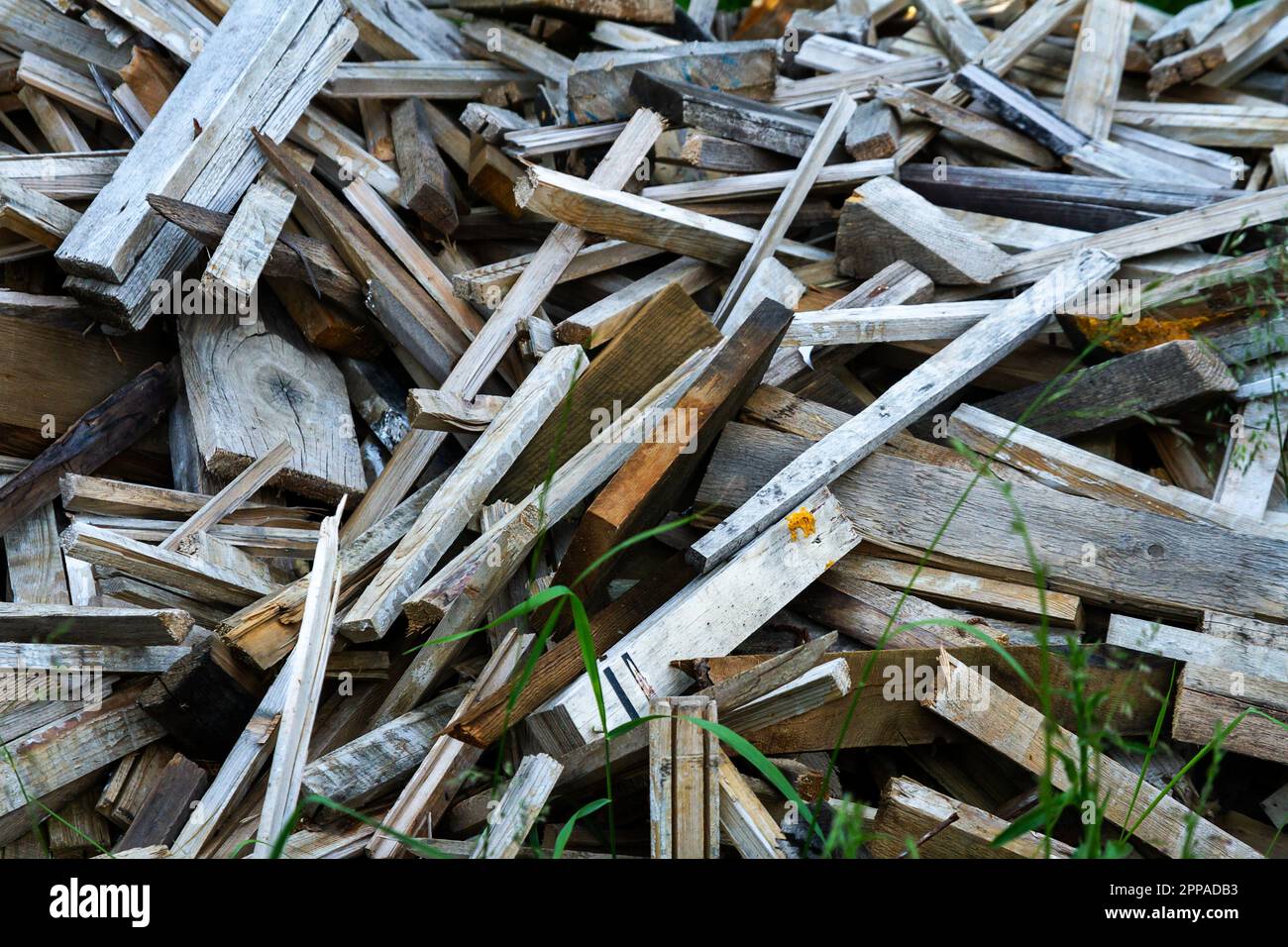 Pile of old timber wood on a backyard. Sawn old boards for firewood ...