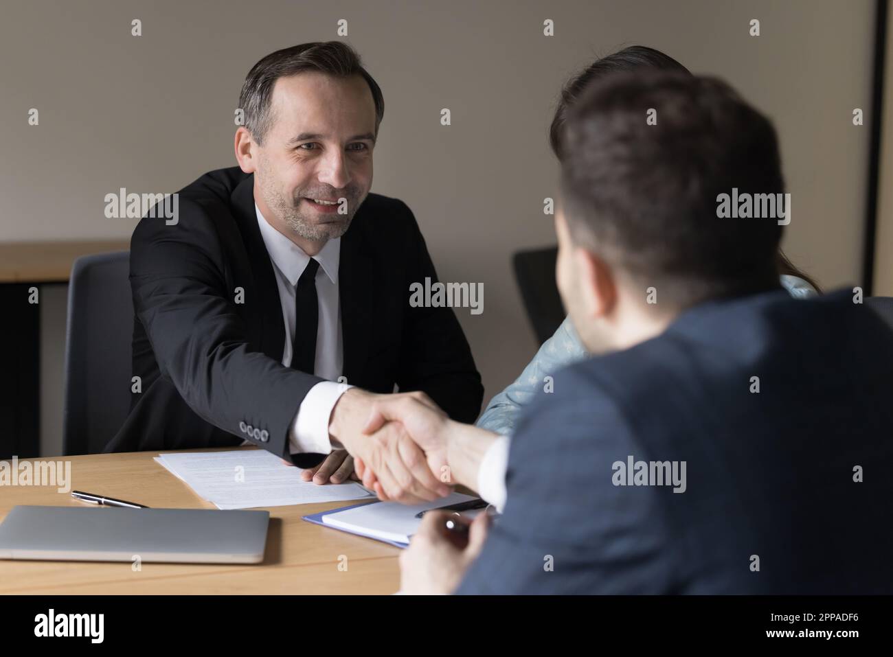 Happy mature business leaders shaking hands after successful ...