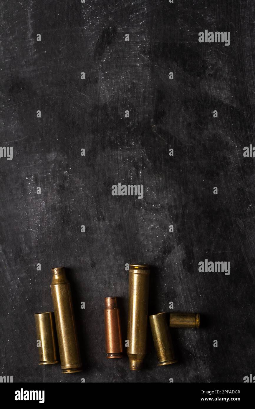 Empty bullet cartridges lying on the black background Stock Photo - Alamy