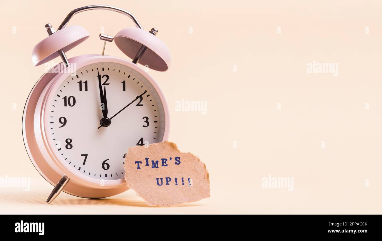 Times up text torn paper near alarm clock against beige background ...