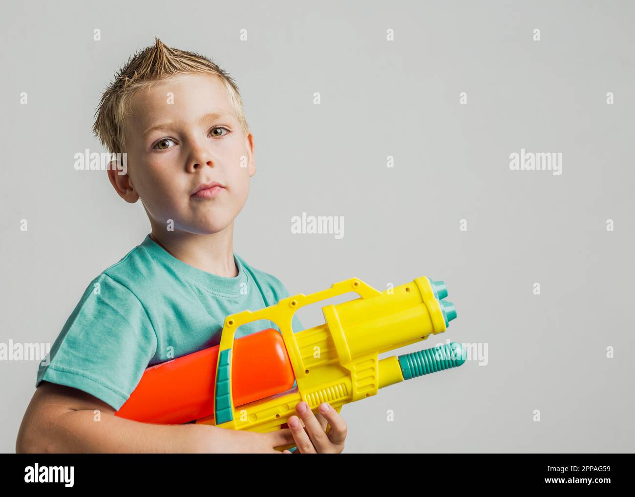 Cute kid playing with water gun Stock Photo - Alamy