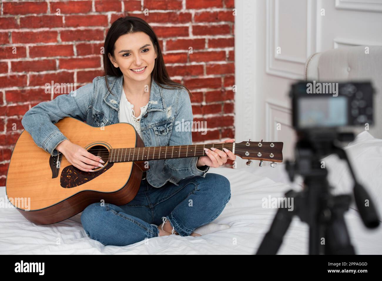 Beautiful young woman playing guitar Stock Photo - Alamy