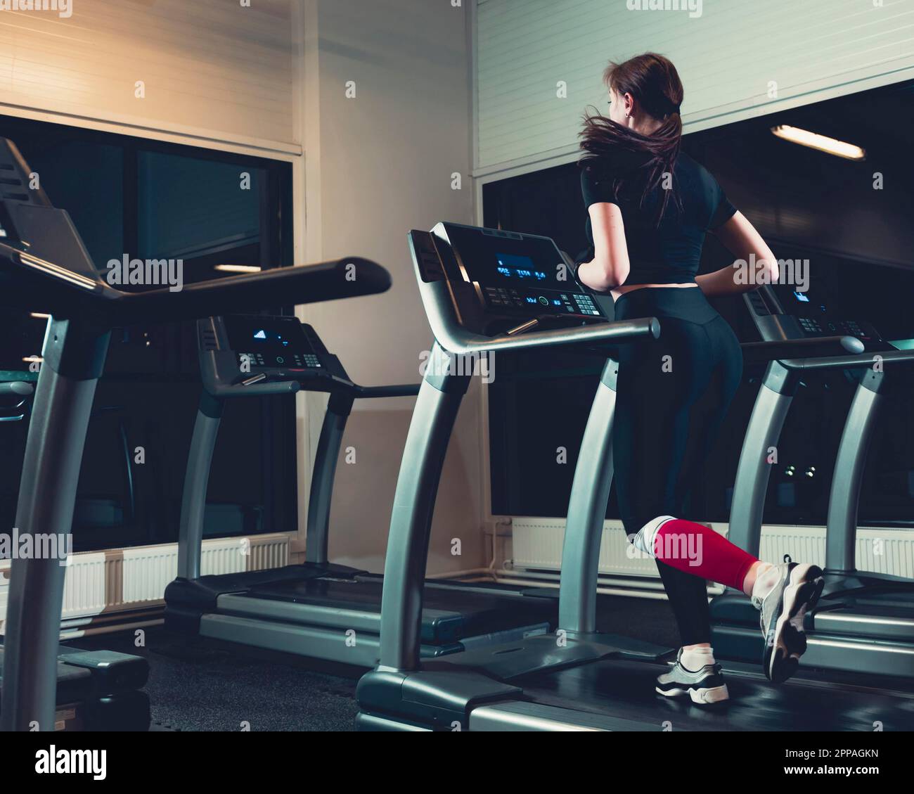 Rear view woman running treadmill Stock Photo - Alamy