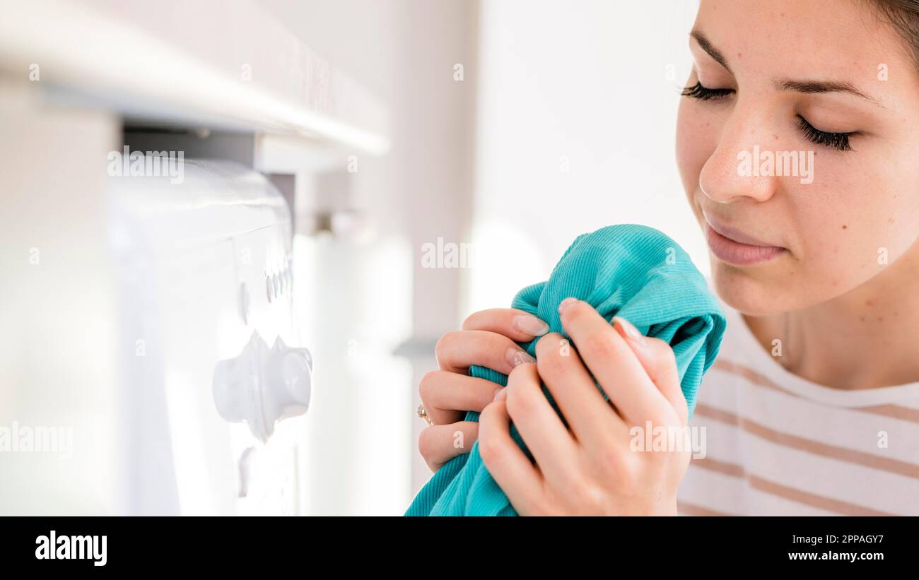 Woman smelling clean laundry close up Stock Photo - Alamy