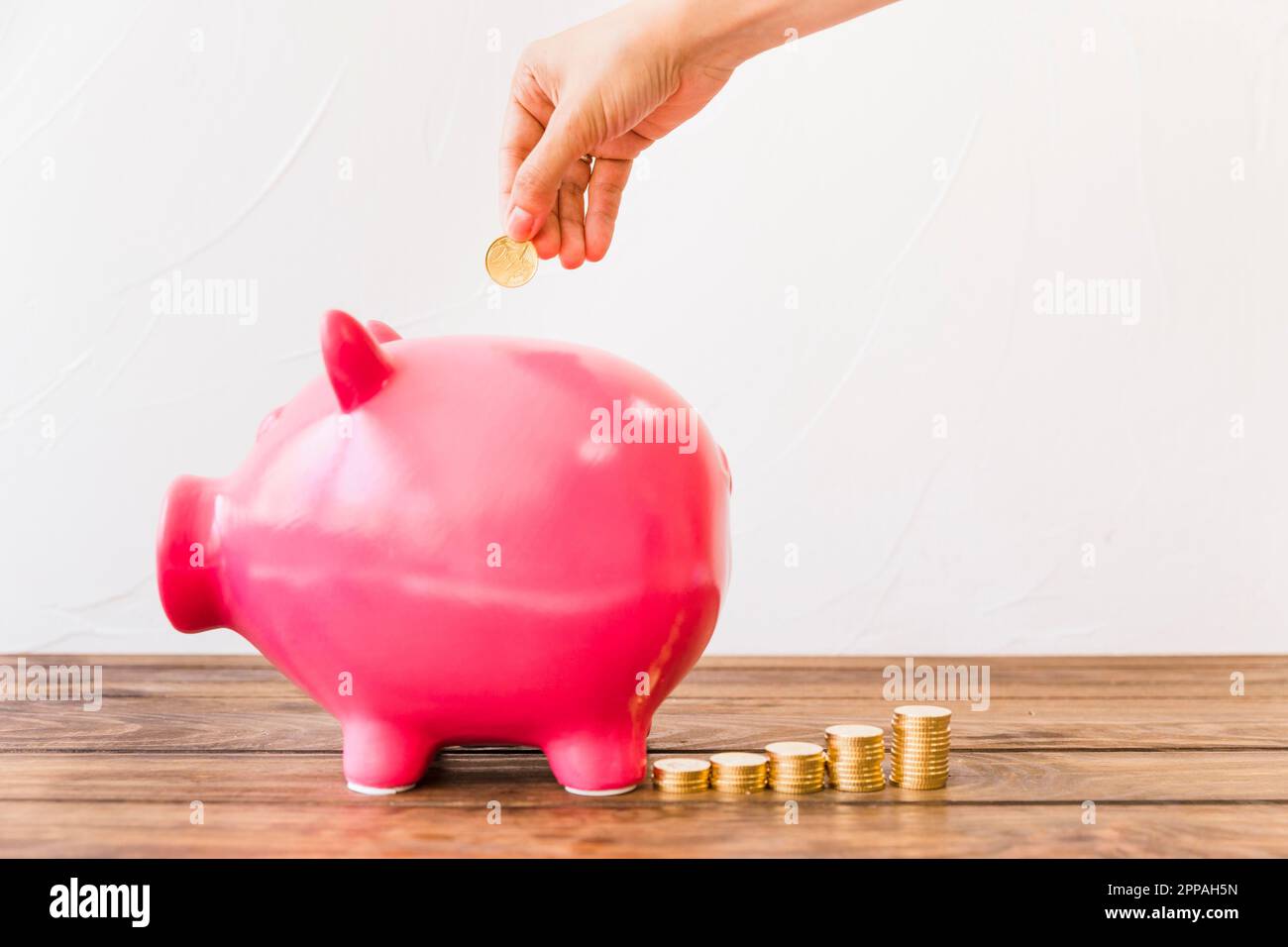 Human hand inserting coin pink piggybank Stock Photo - Alamy Human hand inserting coin pink piggybank Stock Photo - Alamy