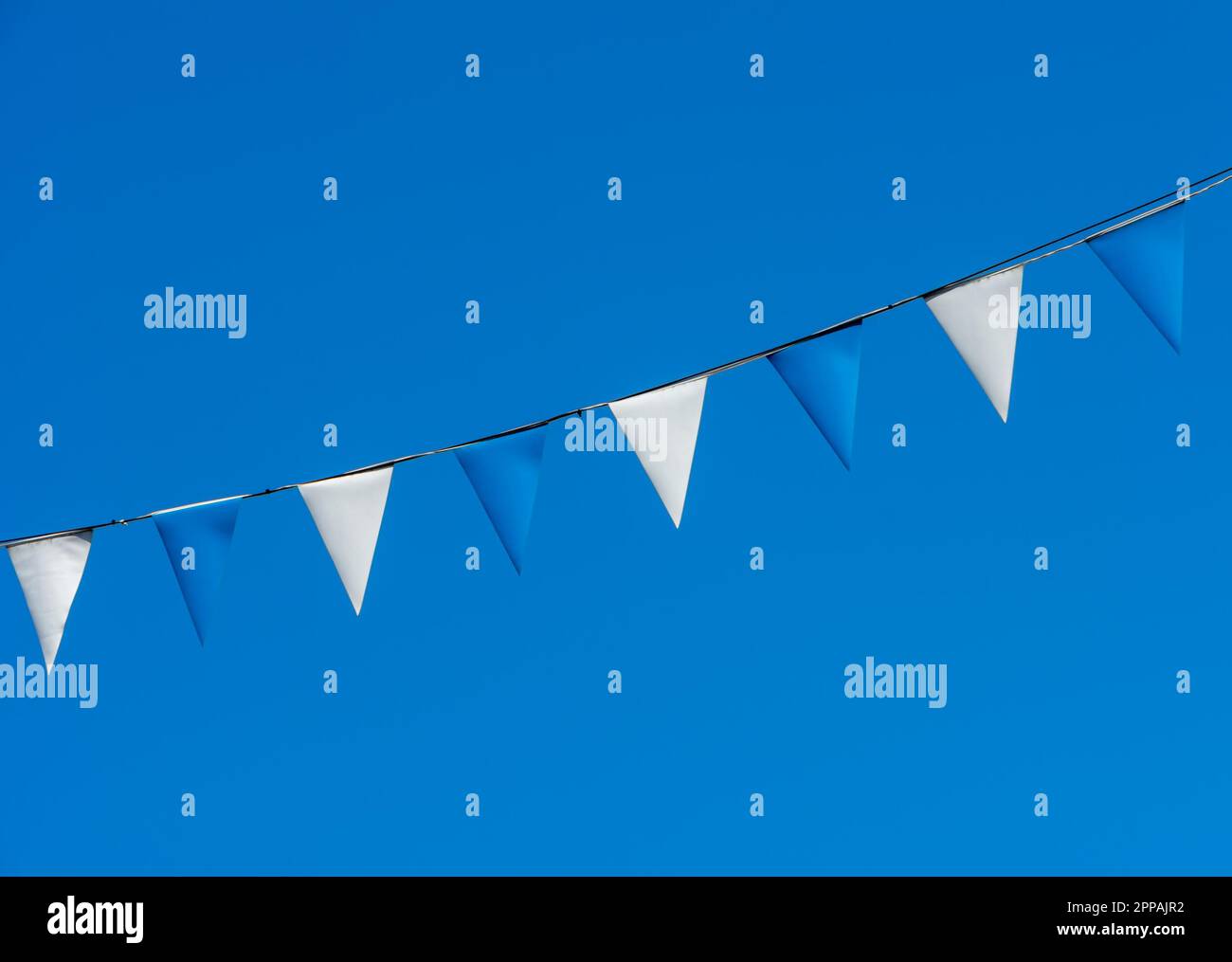 Decoration with blue and white triangular flags against blue sky Stock ...
