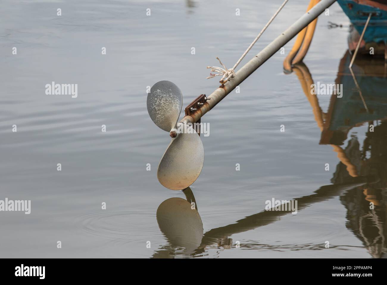 The old long-tailed boat propeller that was rusting was above the water ...
