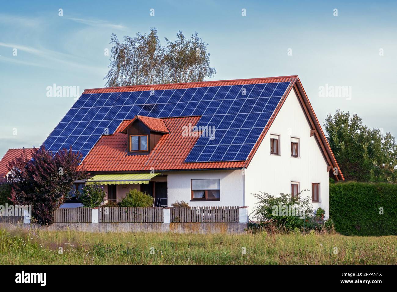 Modern house with solar cells on the roof. House and surroundings ...
