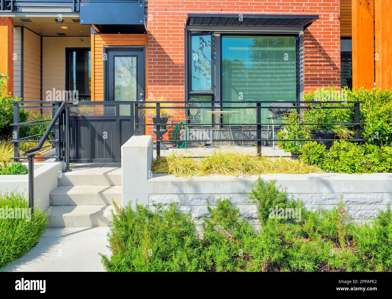Small patio with BBQ in front of private entrance to a residential unit ...