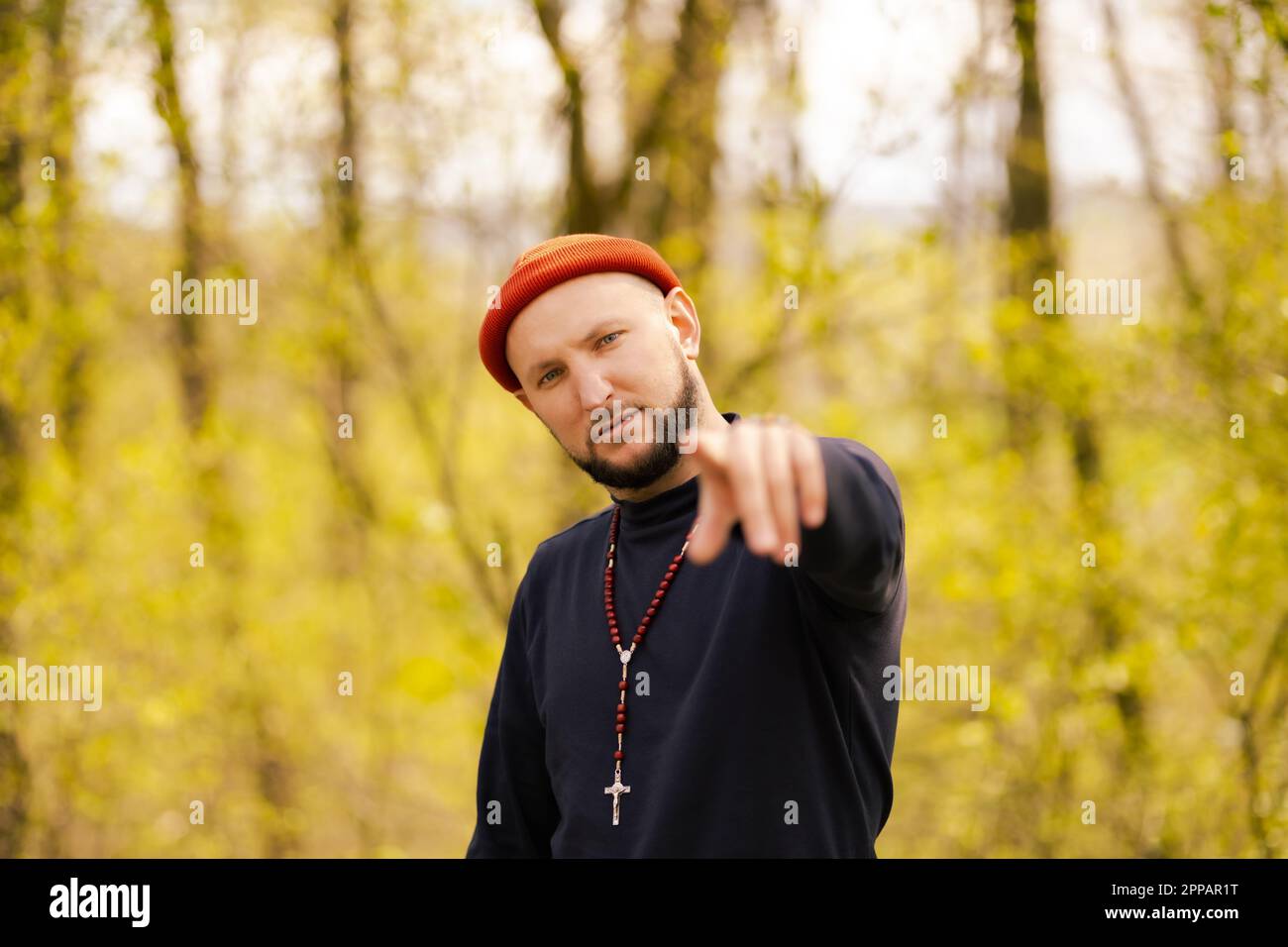A serious man with a cross around his neck looking into your eyes Stock ...