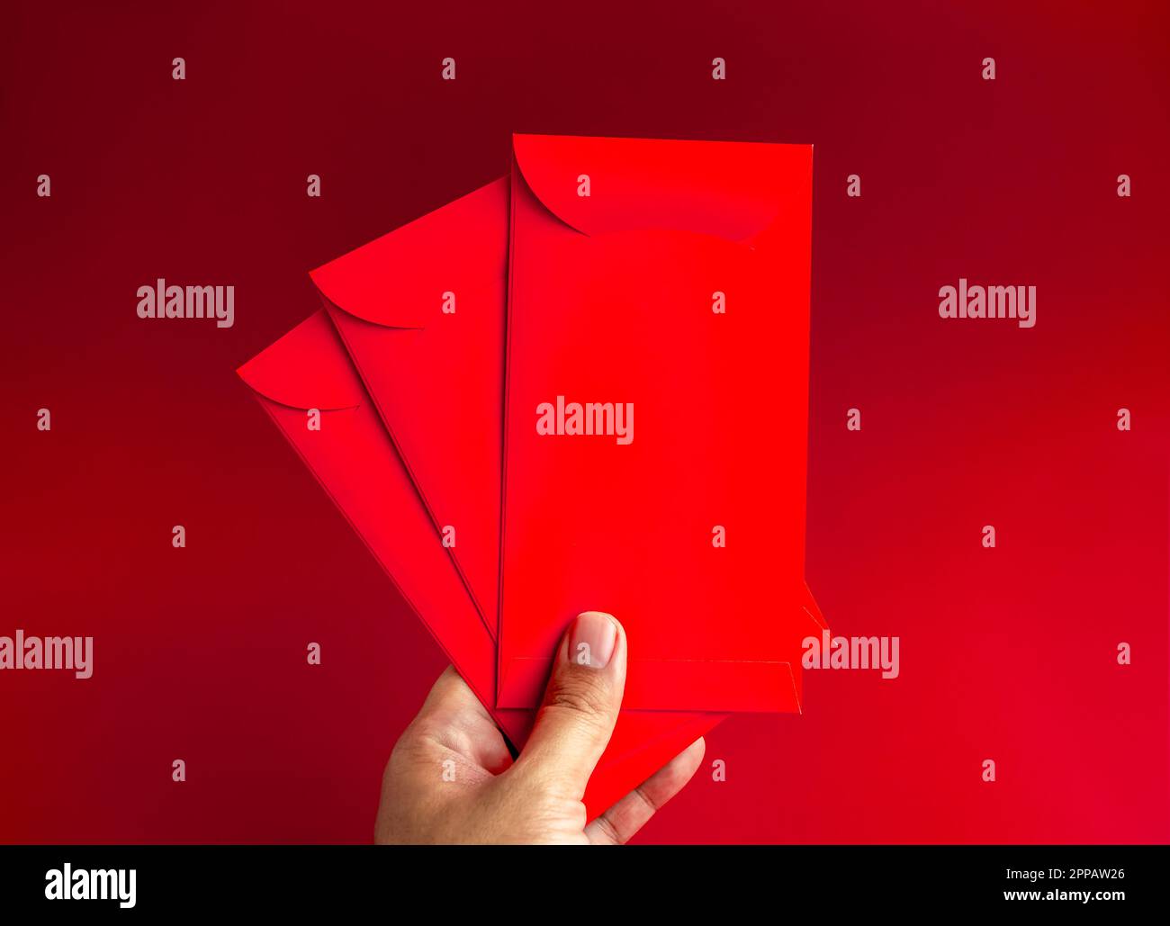 Three red envelope holding by hand isolated on red background. 3 ...