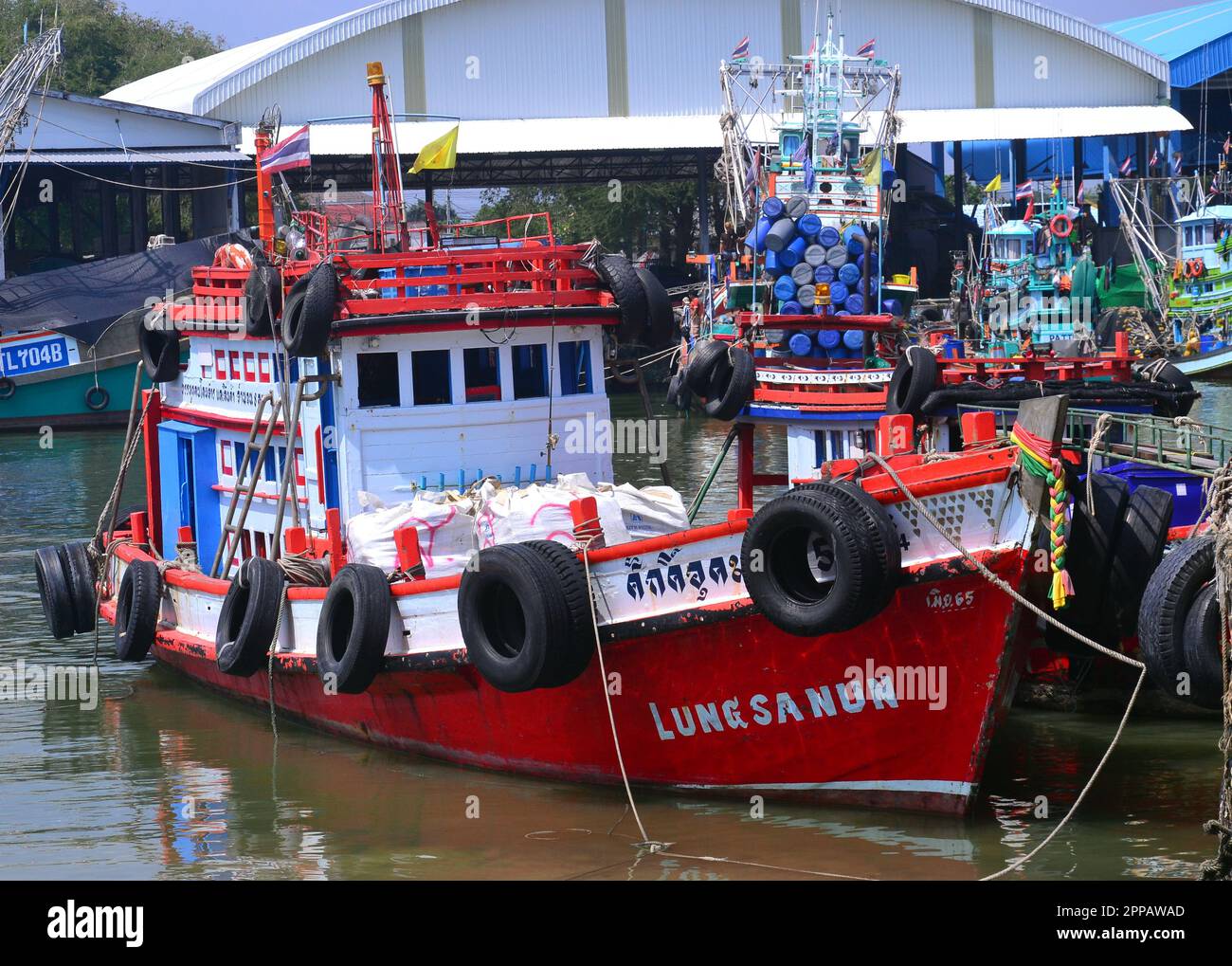 Colourful Thai fishing boats at the harbour on the Rayong River, Rayong Province, Thailand ...