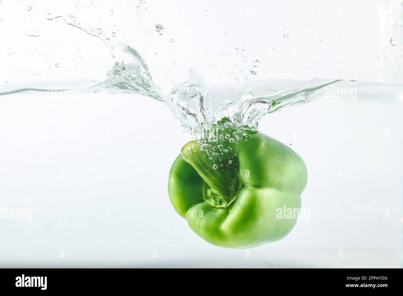 Sweet pepper in water splashes, green sweet pepper on a white ...