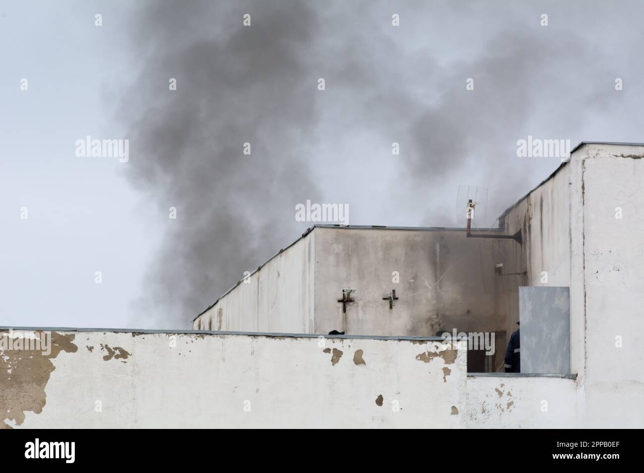 Burning roof of a residential high-rise building, clouds of smoke from ...