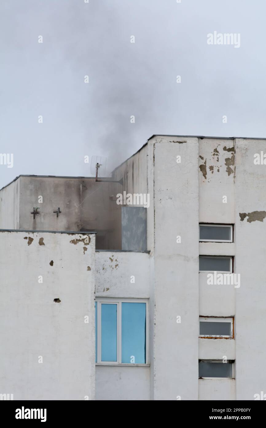 Burning roof of a residential high-rise building, clouds of smoke from ...