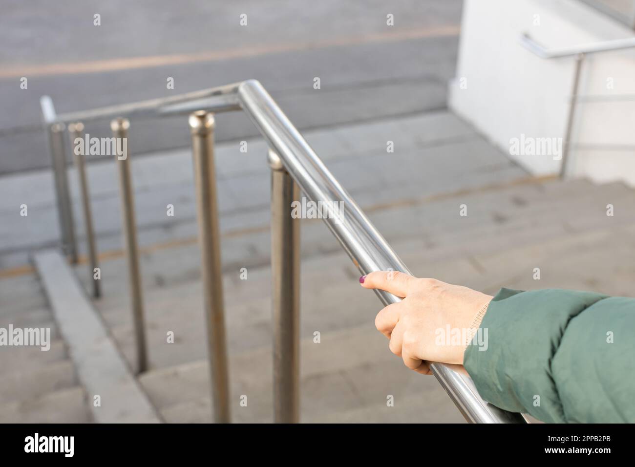 woman holding on to the railing going down the stairs. hand holding the ...