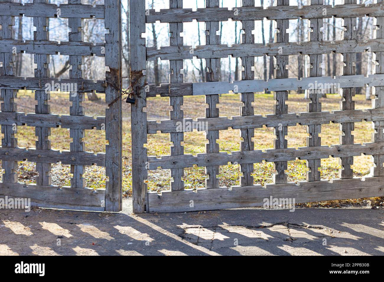 wooden gate closed on a chain with a lock. old gate. wooden lattice ...