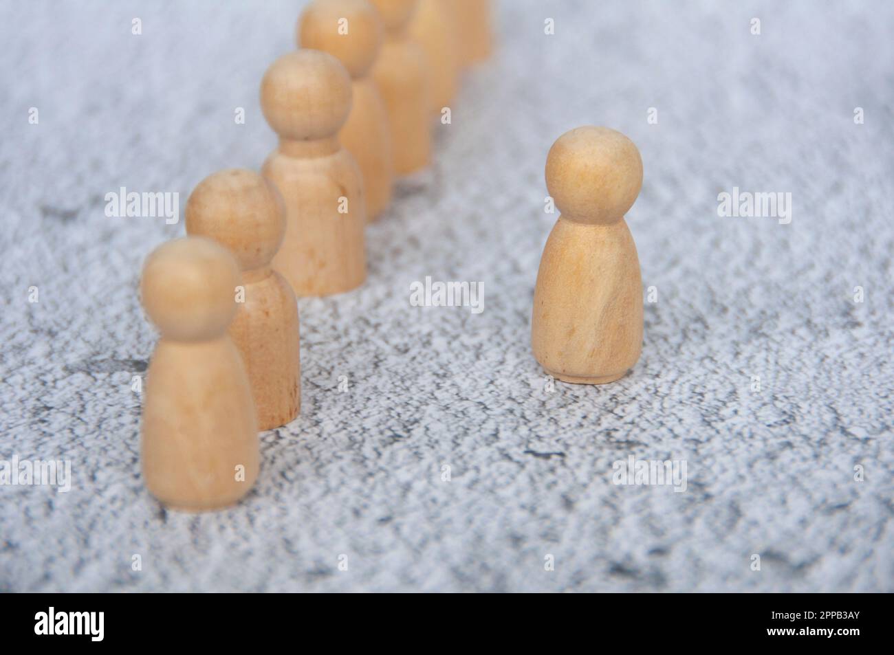 A wooden figure taking the first step out from the rest of the figure ...