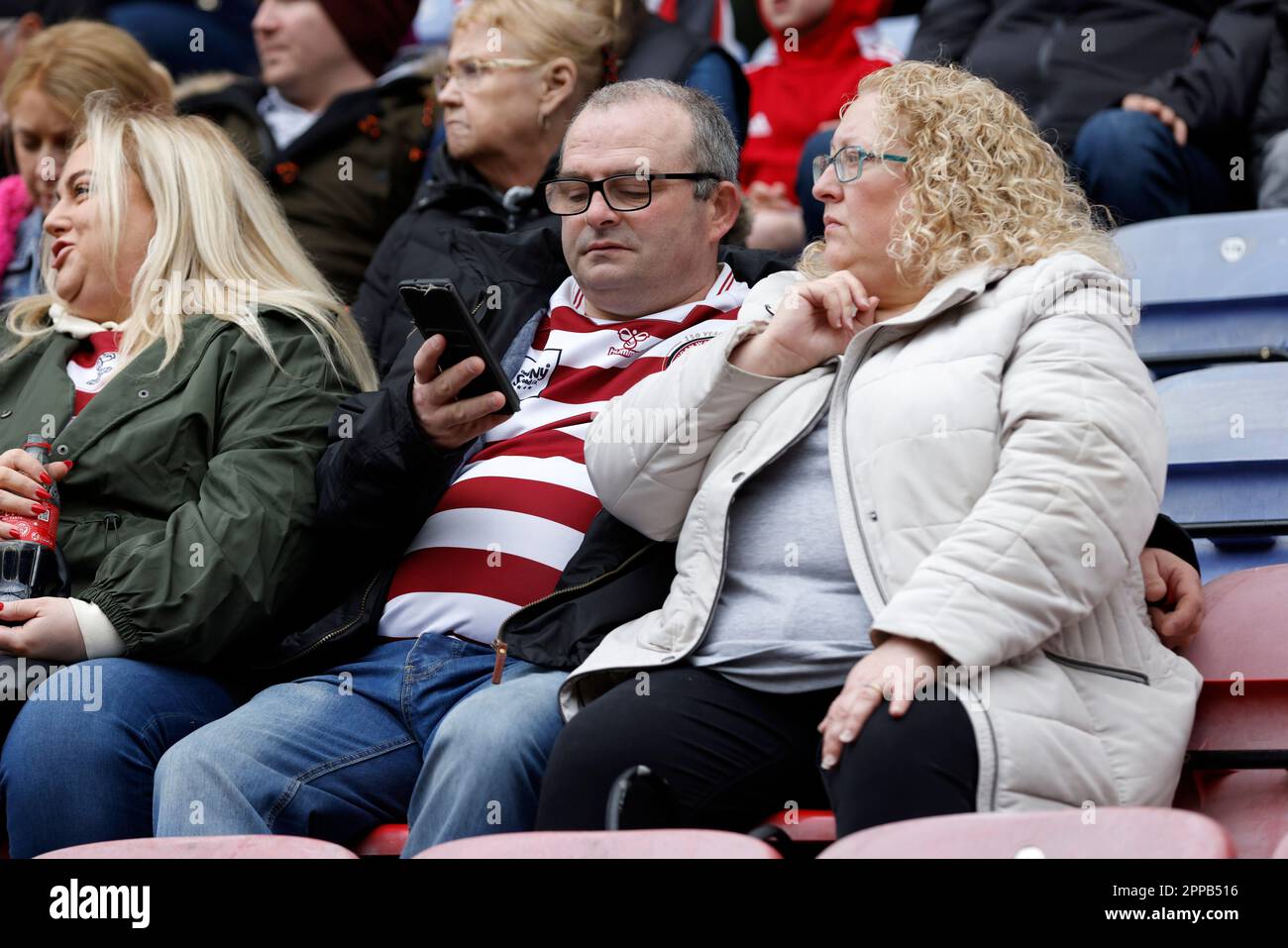 Fans check their phones as the UK-wide emergency alert system shows on ...