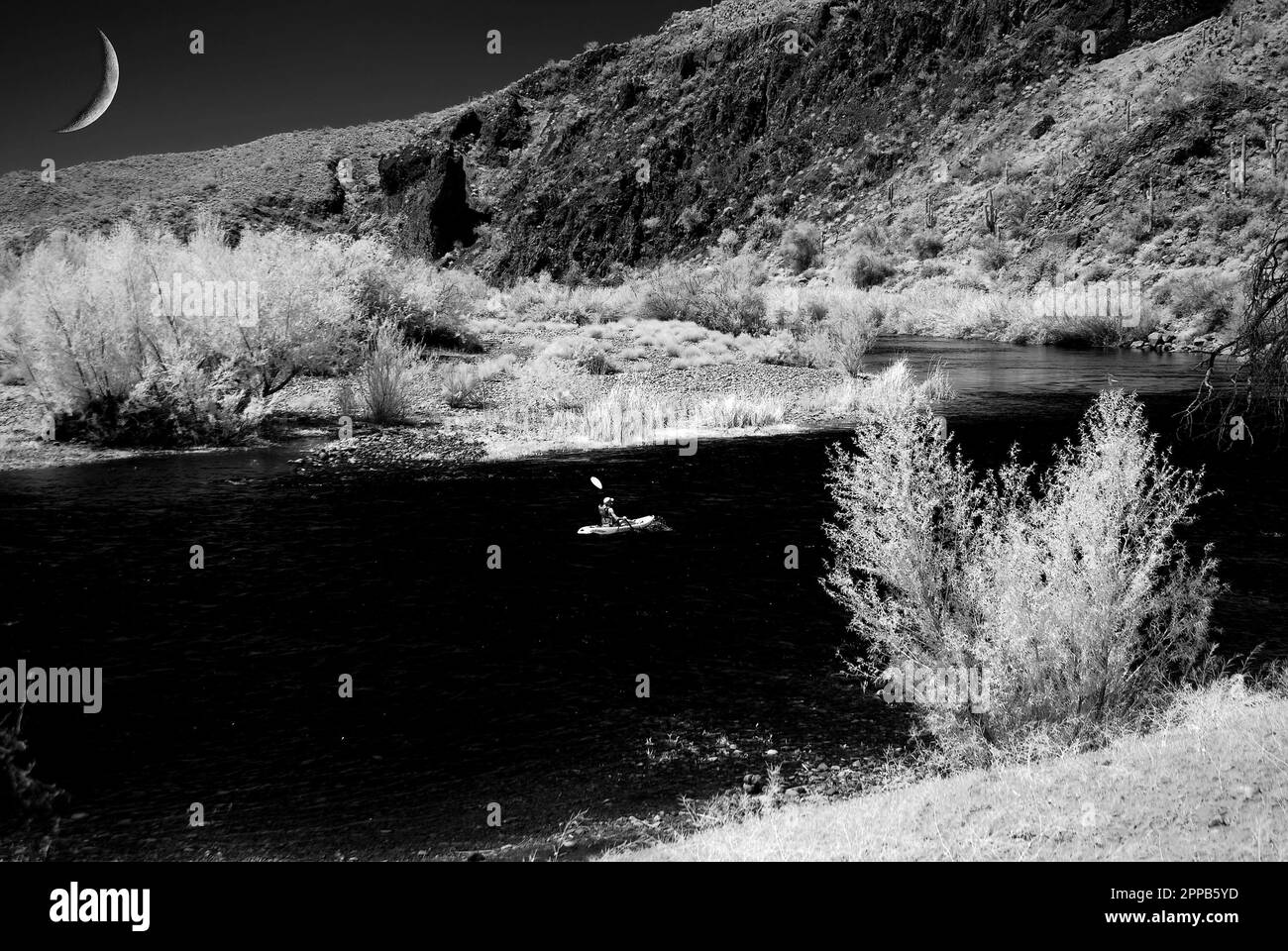 Kayak on desert river with crescent moon Stock Photo - Alamy