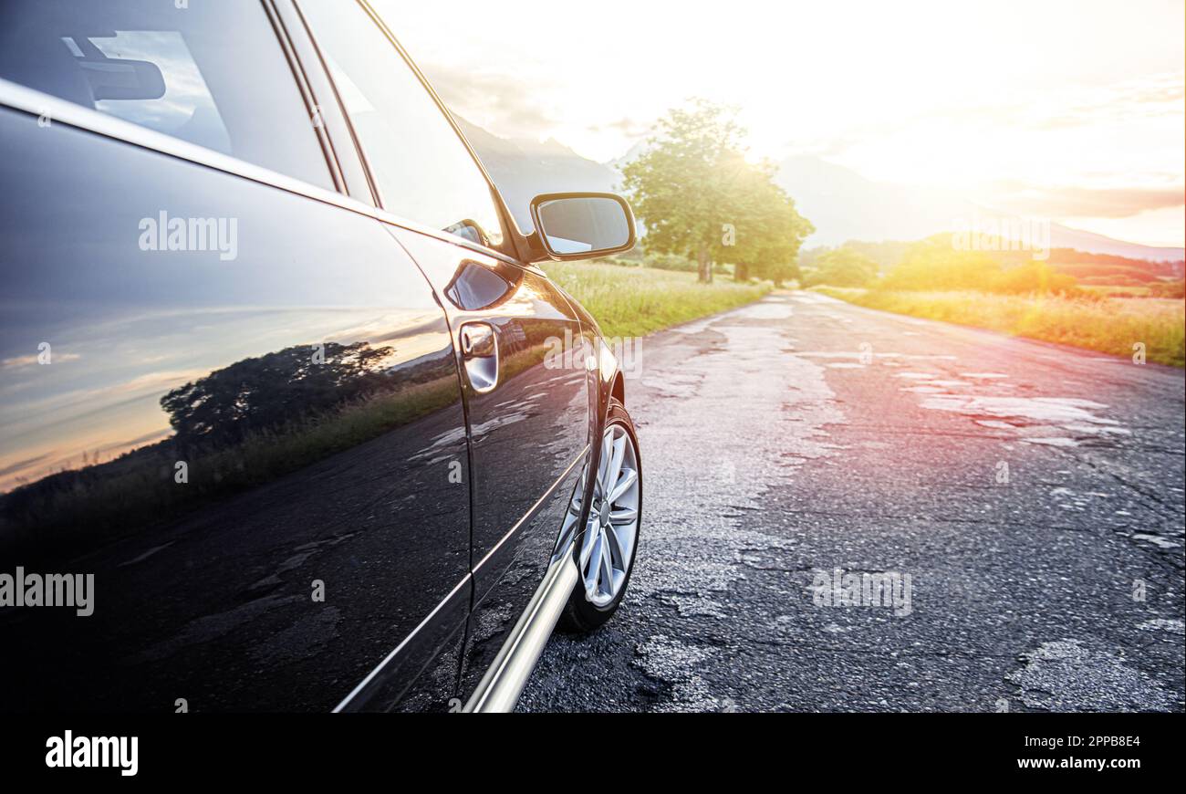 Car on a road against the backdrop of mountains and sunset Stock Photo ...