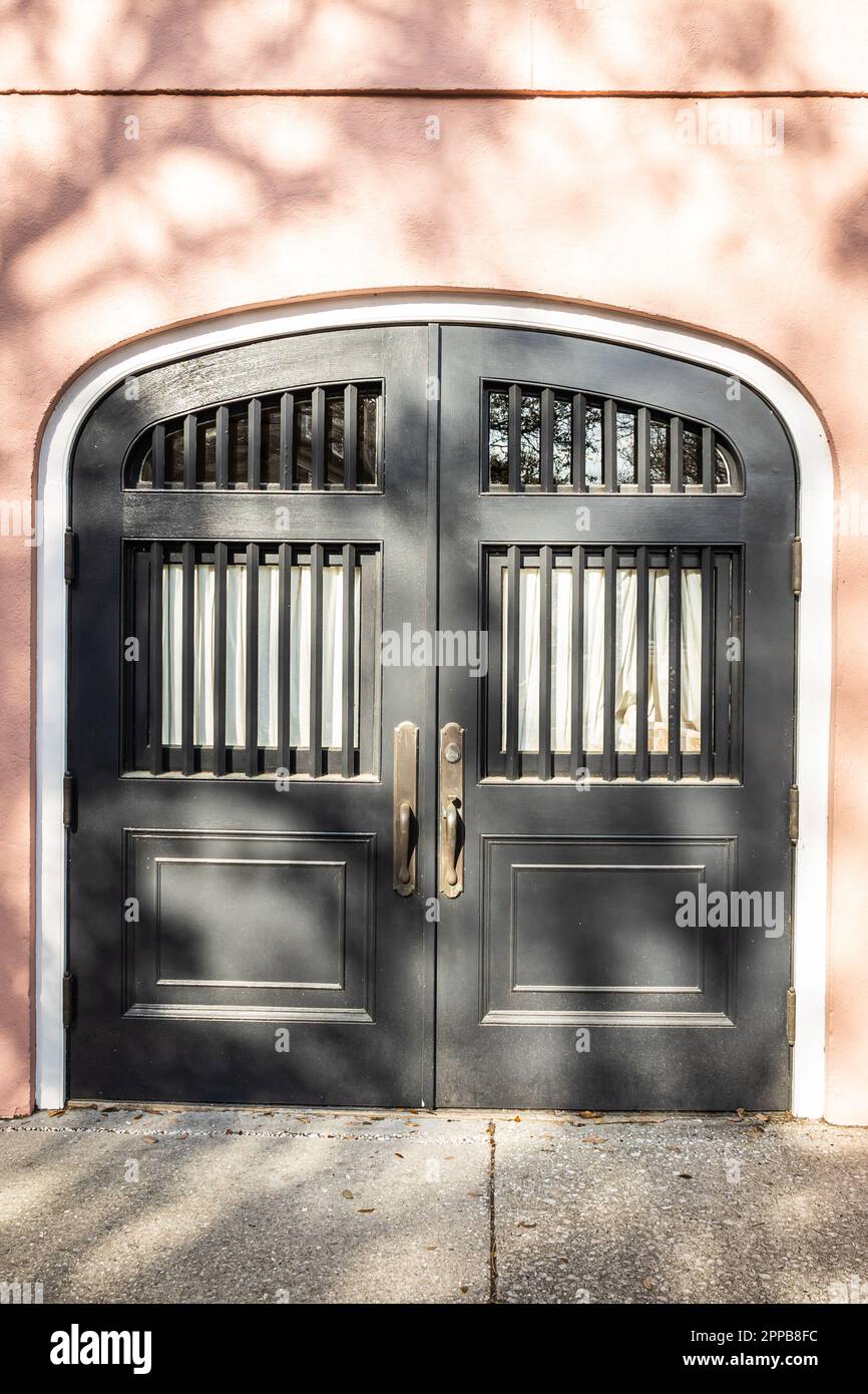 A unique dark blue garage door with an arched top and a light blue wall ...