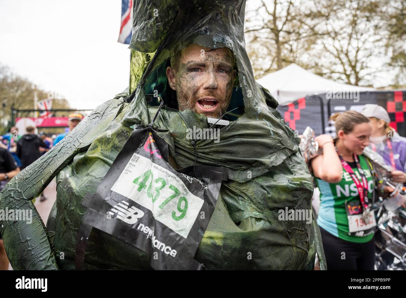 London, UK. 23 April 2023. A runner dressed as a dinosaur at the finish ...