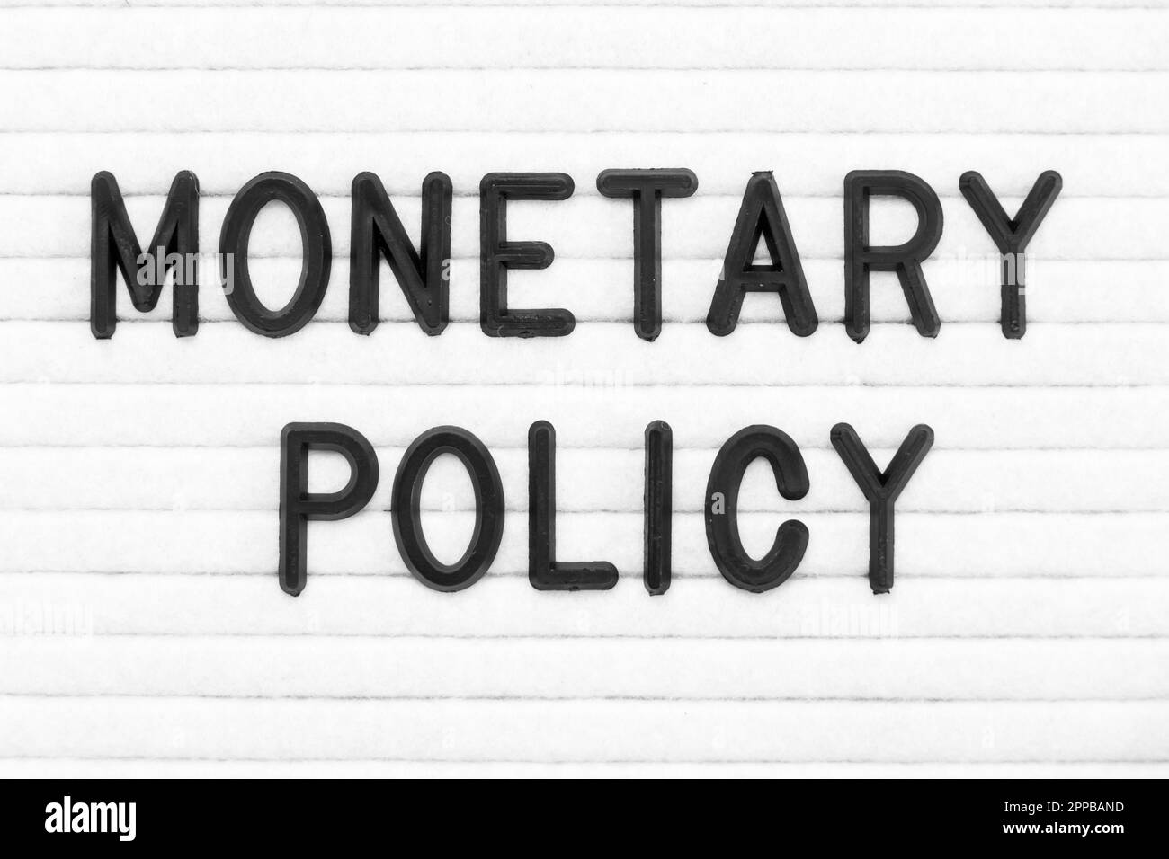Black color letter in word monetary policy on white felt board ...