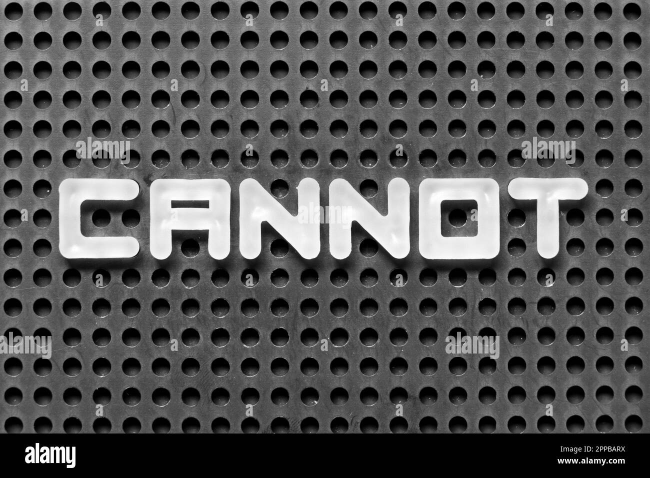 White alphabet letter in word cannot on black pegboard background Stock ...