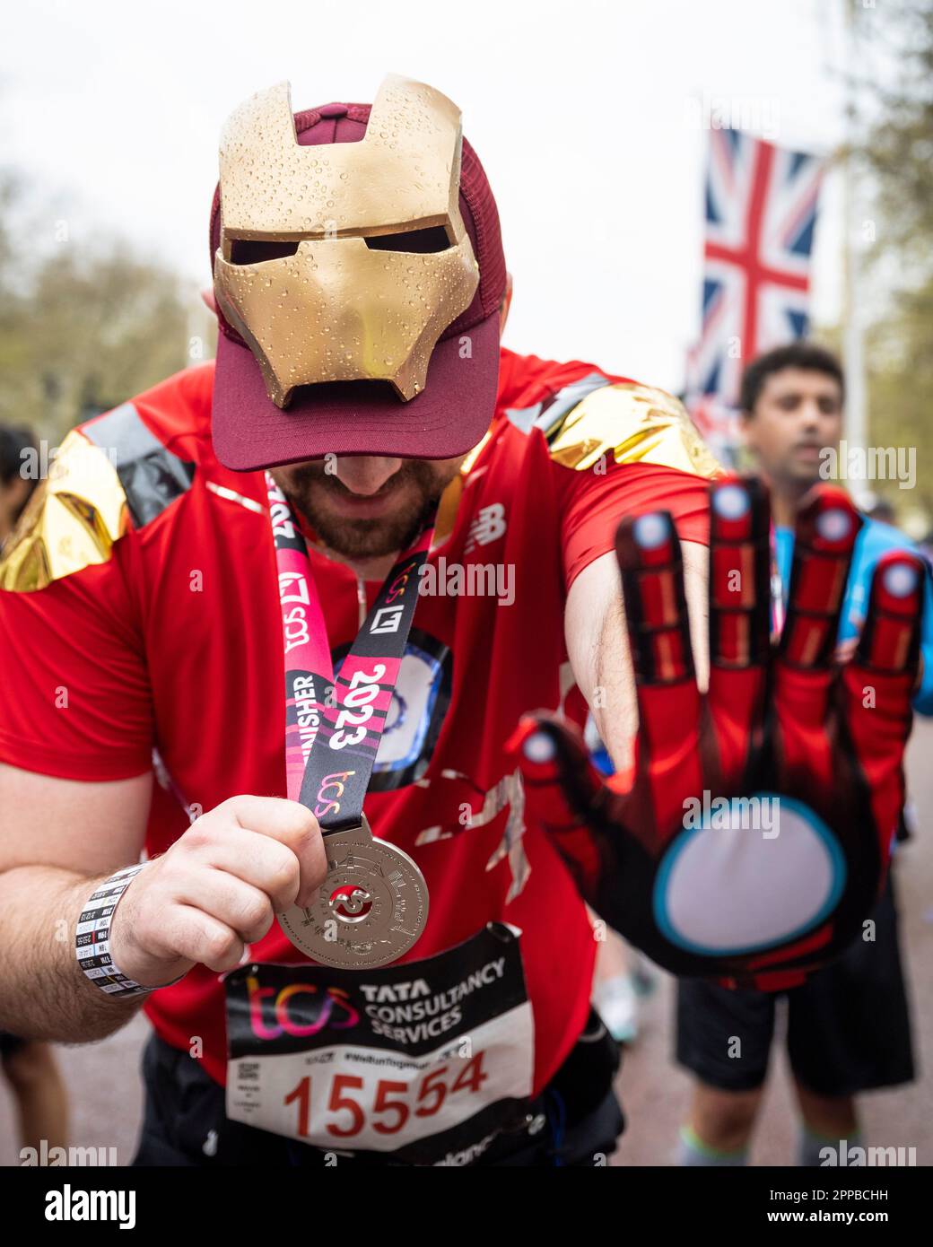 London, UK. 23 April 2023. A runner dressed as Iron Man with his medal ...