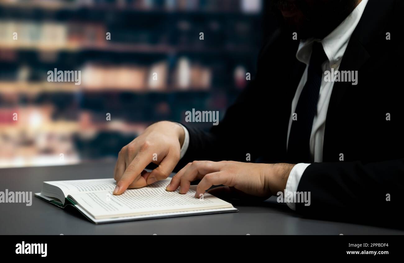 Black suit-clad businessman or lawyer studying law book background of ...
