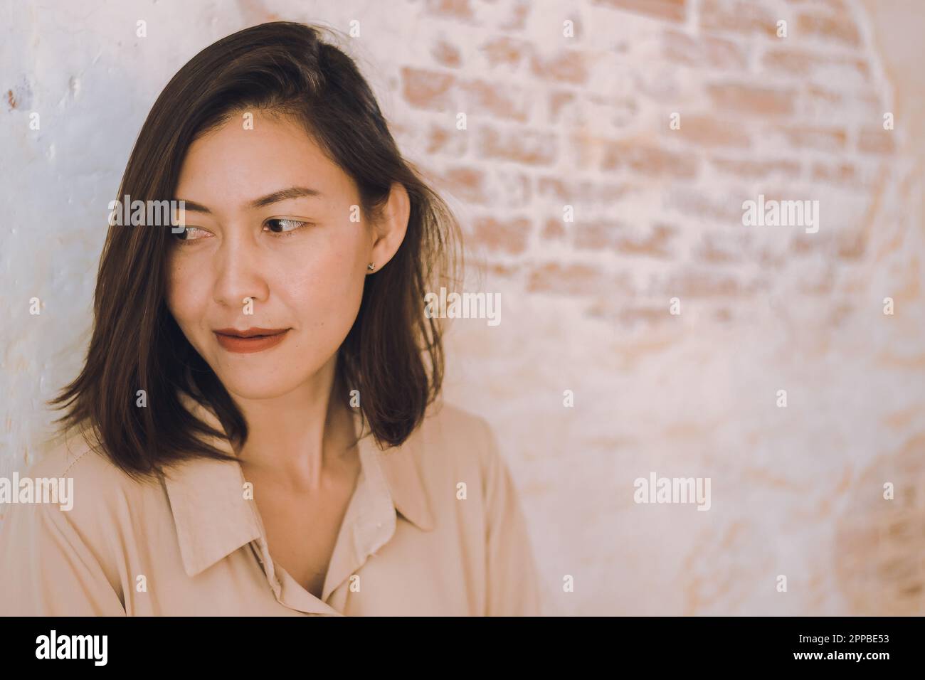 Women are standing against old white brick walls Stock Photo - Alamy