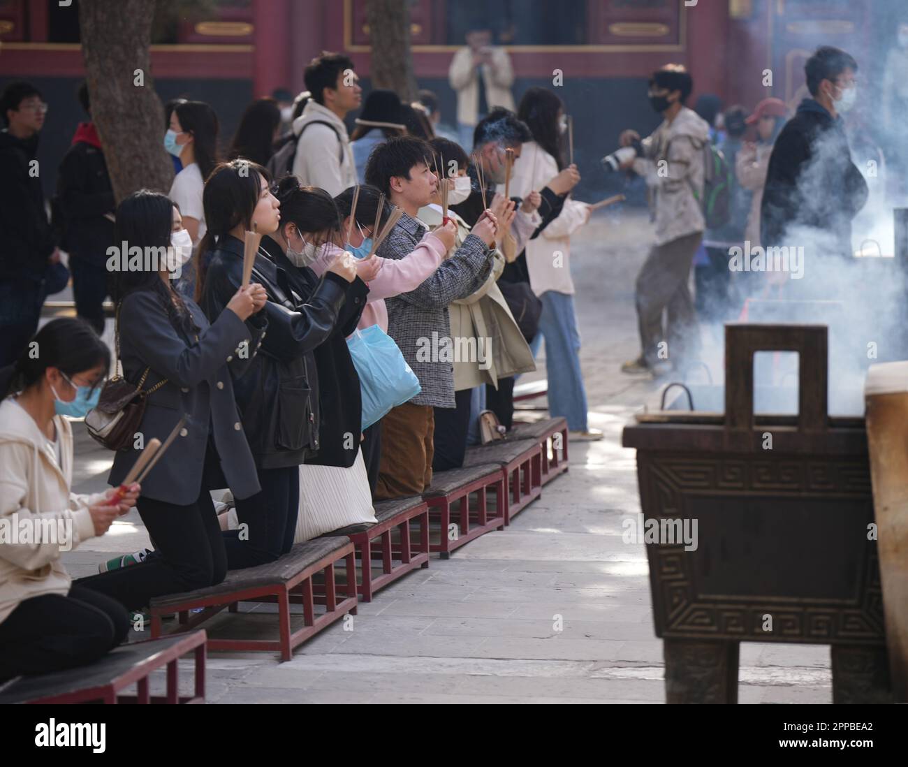 Peking, China. 14th Apr, 2023. Visitors to the Lama Temple kneel and ...