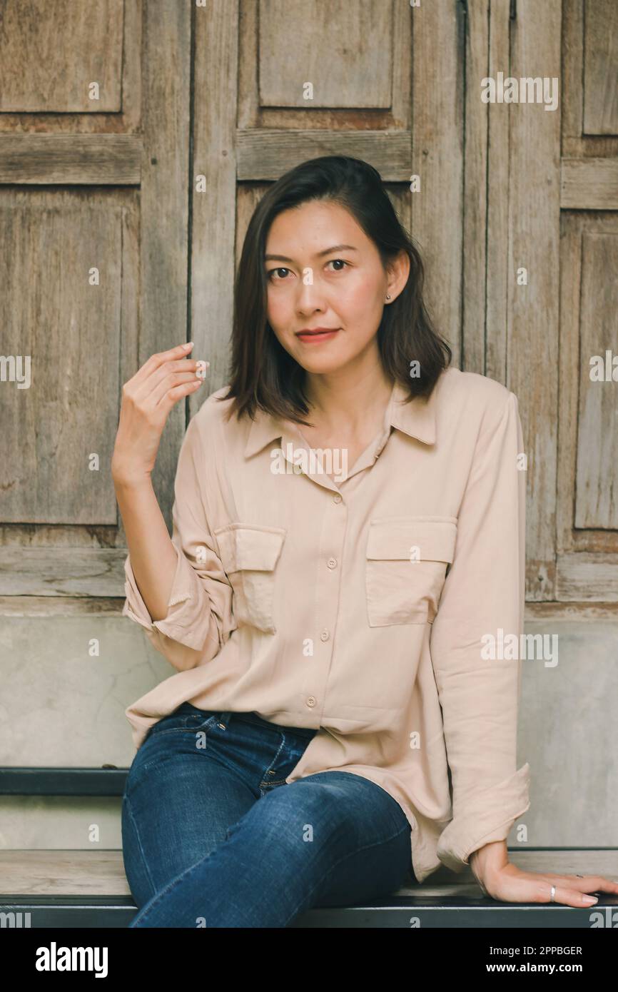 Women are sitting against the wooden window Stock Photo - Alamy