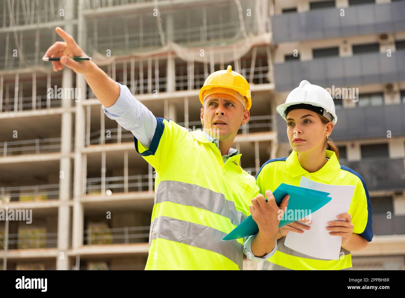 Civil engineers checking work process in construction site Stock Photo ...