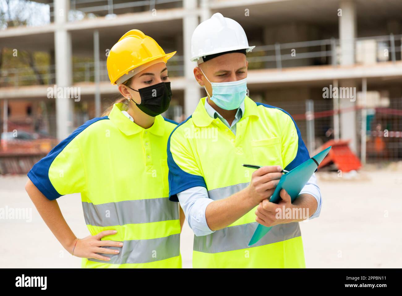 Civil engineers in masks checking work process Stock Photo - Alamy