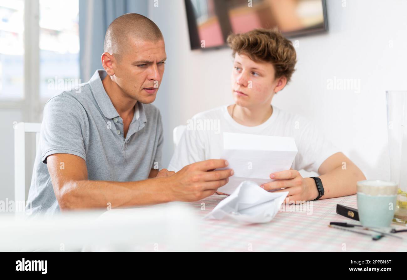 Father reassures his son after reading letter from college Stock Photo ...