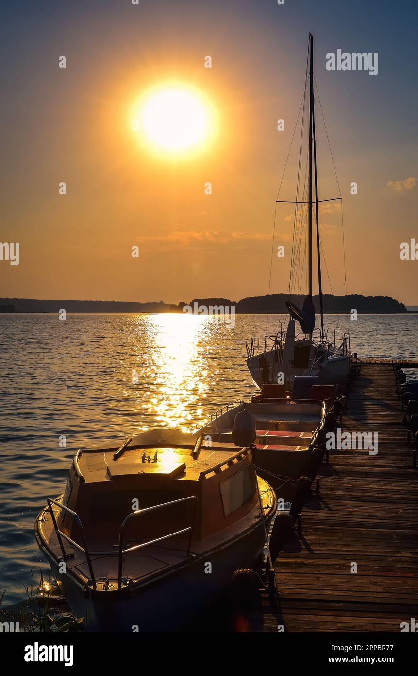 Sailing yacht and jetty in the beautiful lake. Empty wooden jetty with ...