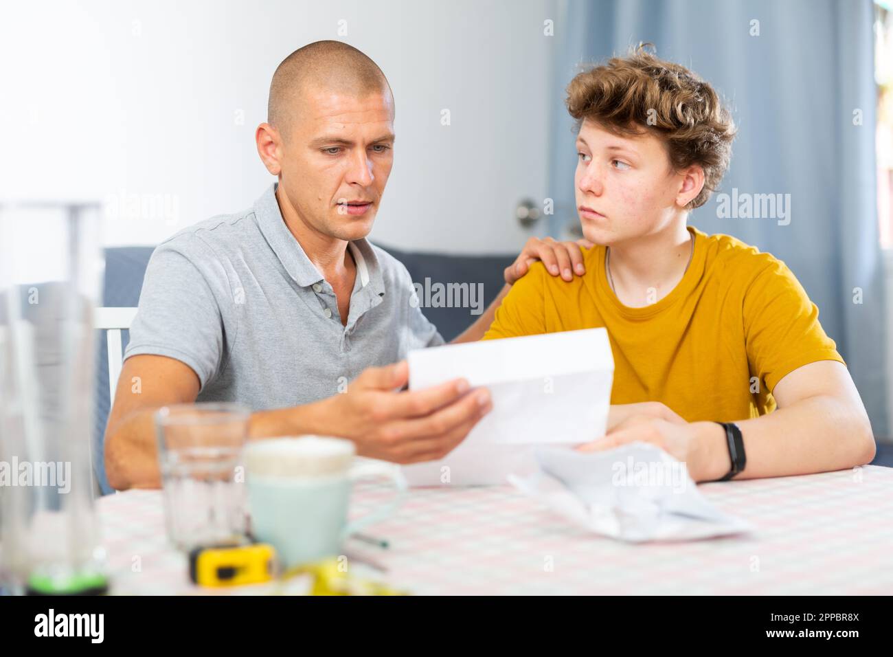 Father reassures his son after reading letter from college Stock Photo ...