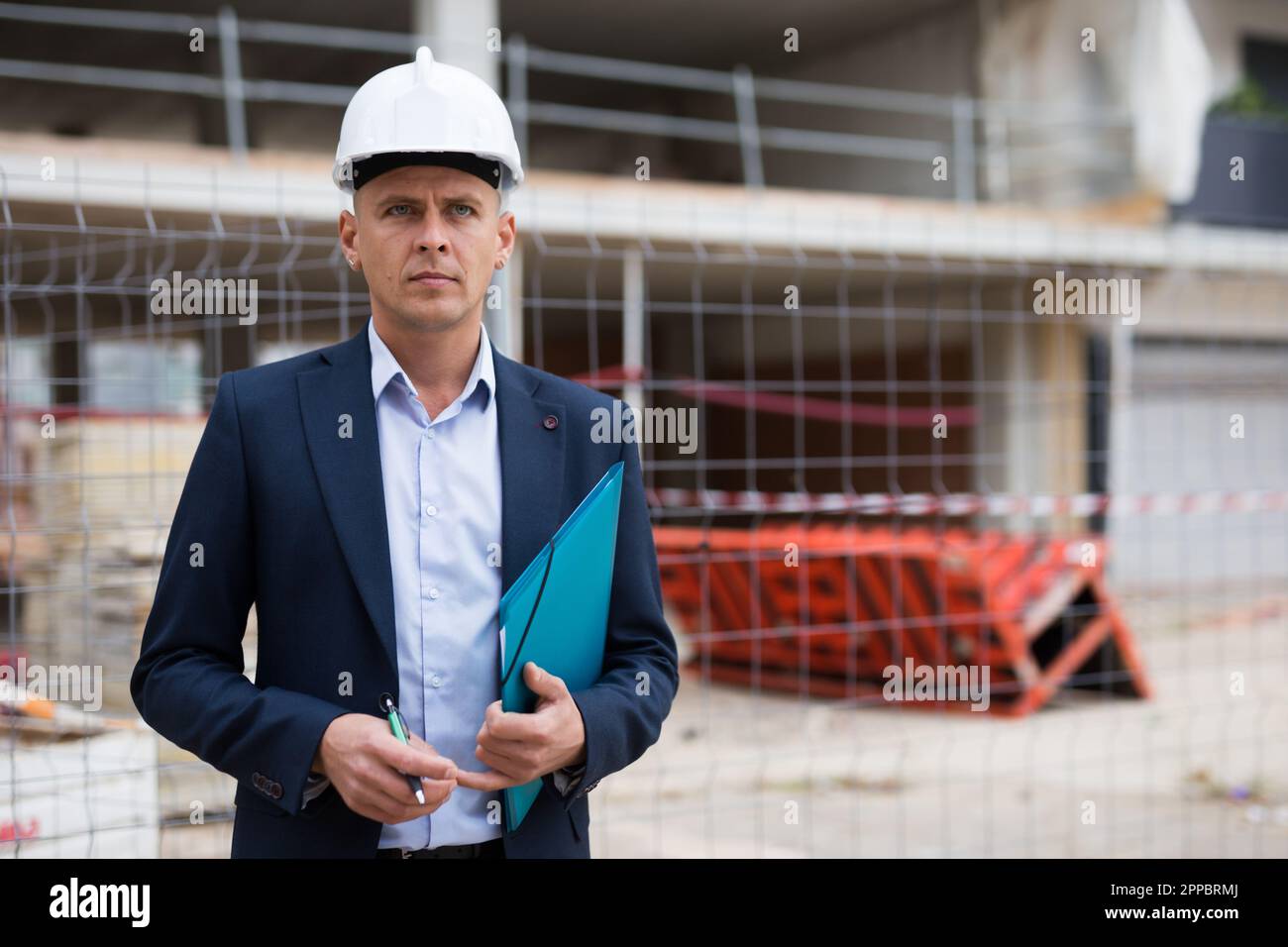 Male engineer checking work process in construction site Stock Photo ...