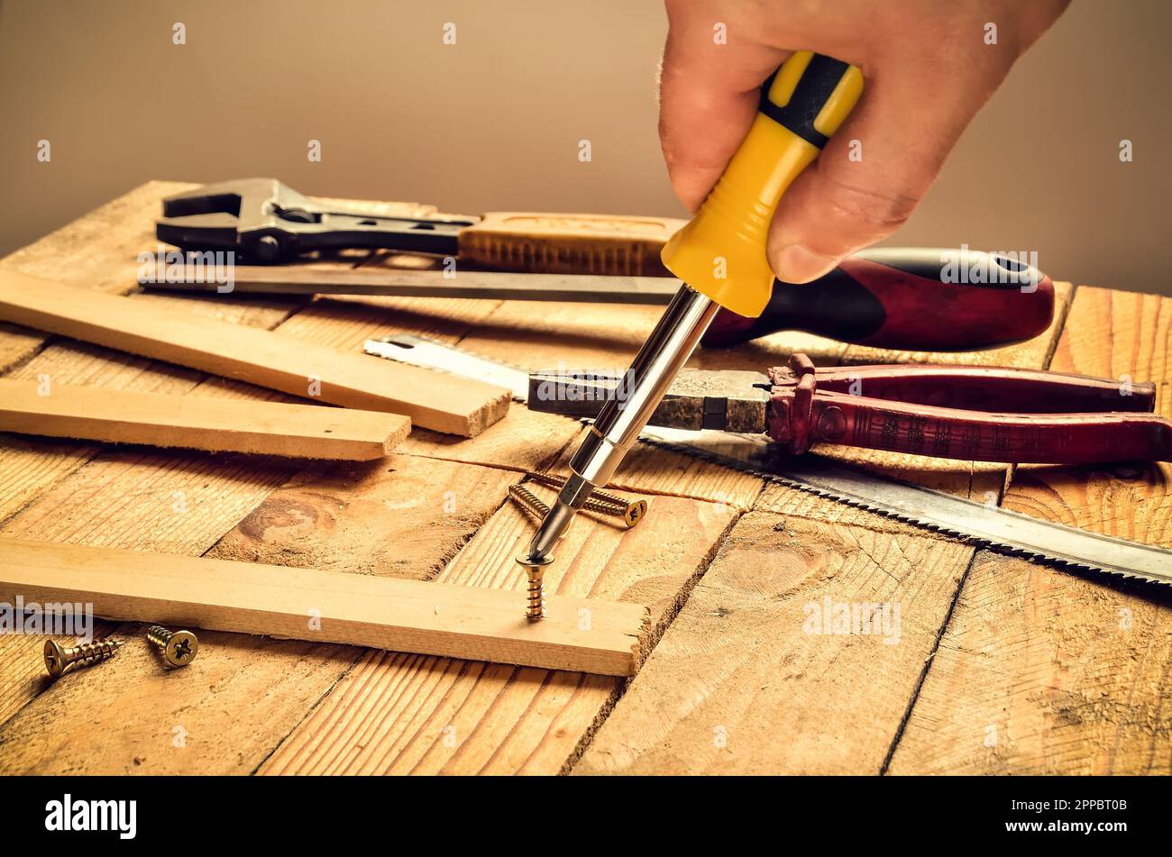 Hand holding tool in the workshop. Screwdriver, flat file, pliers ...
