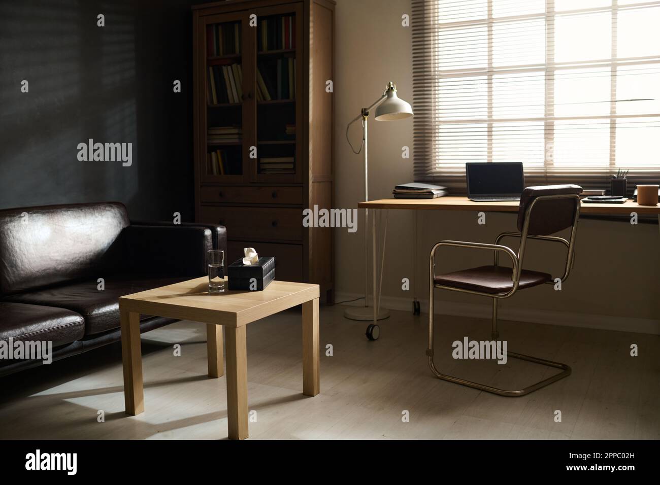 Workplace of psychologist by window and small square wooden table by ...