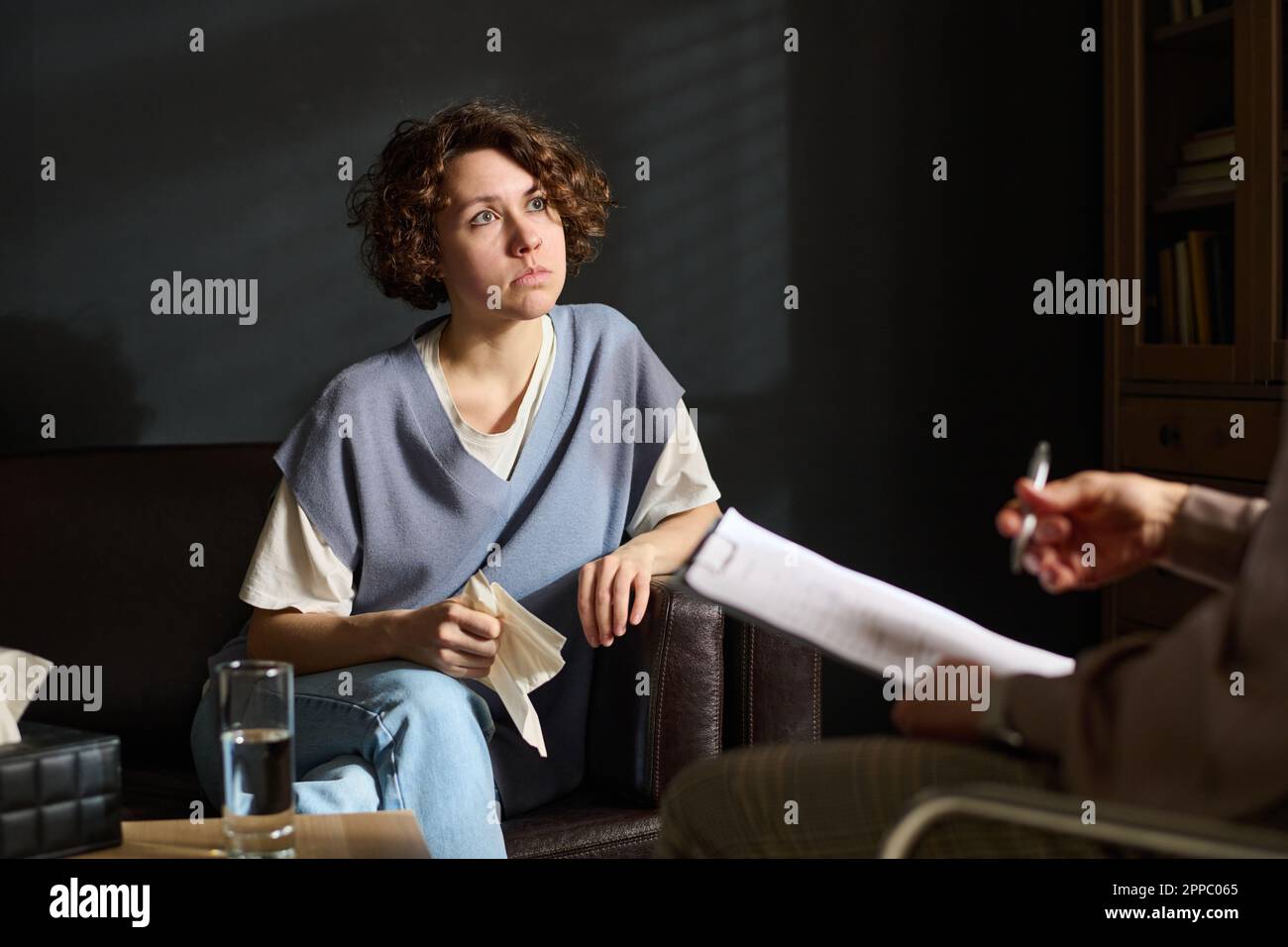 Upset young female patient of psychologist looking at counselor giving ...