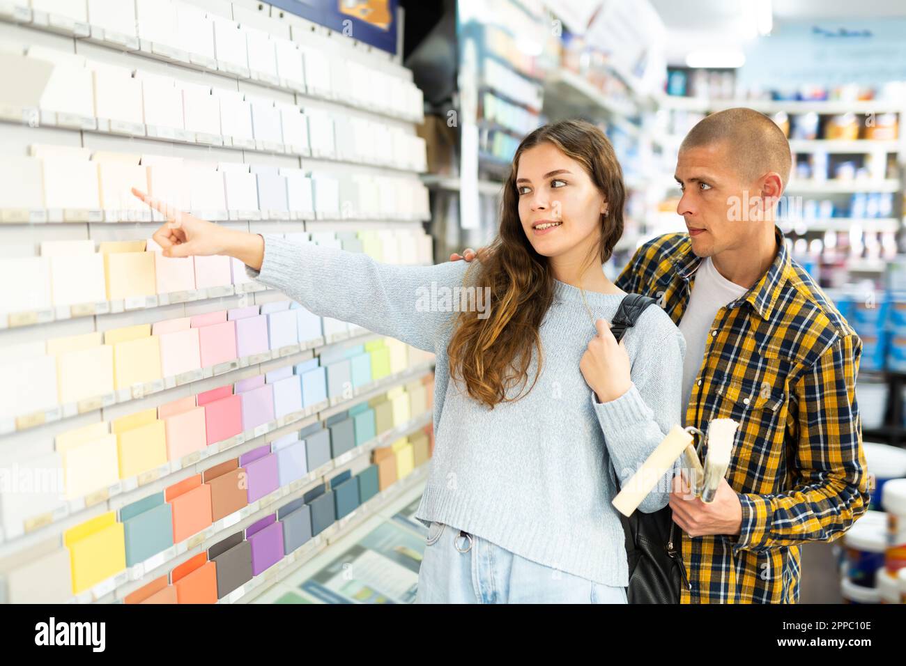 Woman and man consumer choosing tiles color samples in hardware store ...