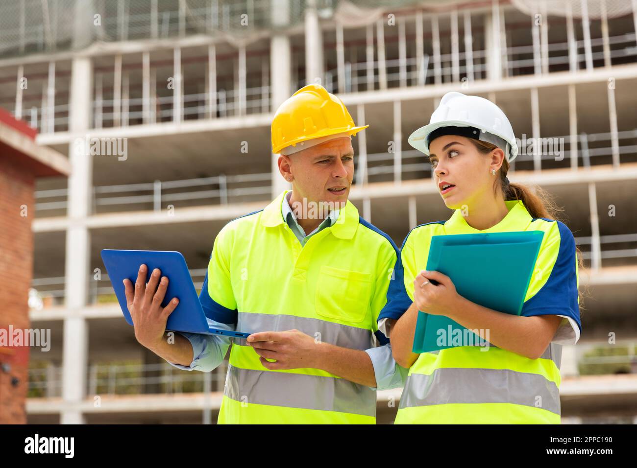 Two builders planning their work in construction plant Stock Photo - Alamy